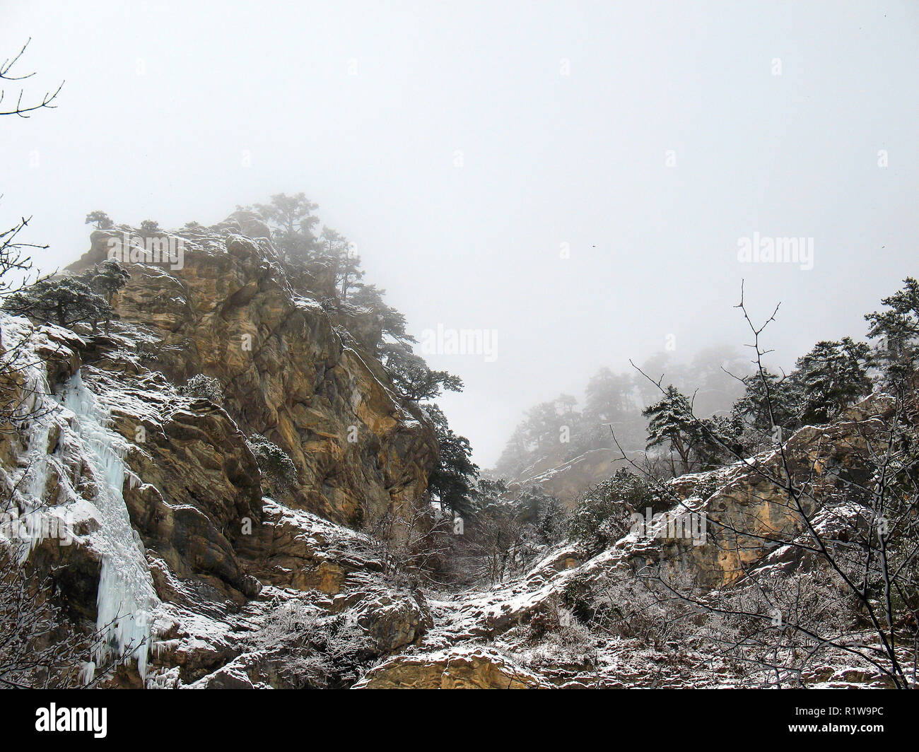Towering orange snow covered rocks. Frozen waterfall. Cascading ...