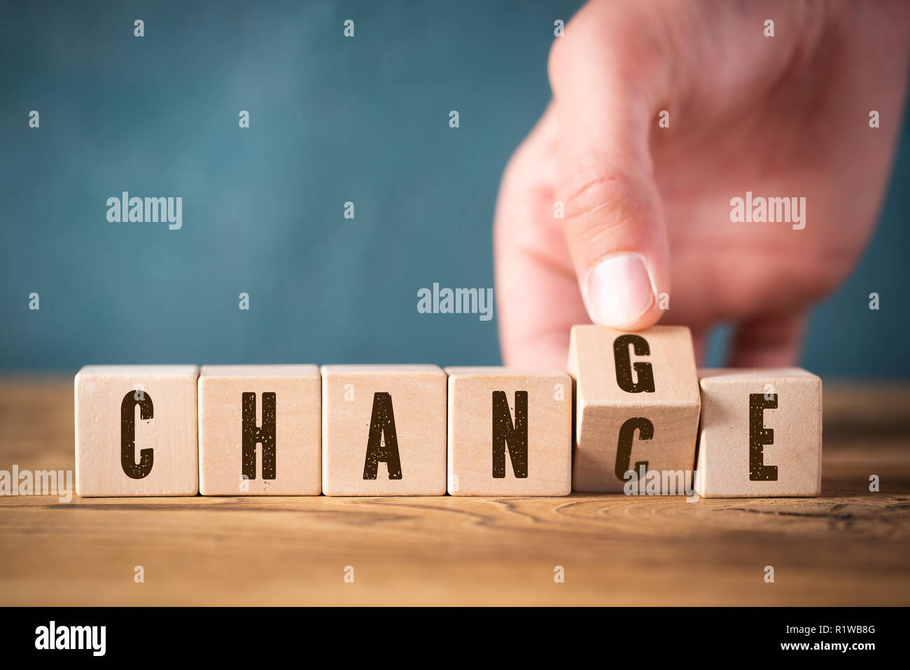 hand flipping one of six cubes, turning the word "change" to "chance ...