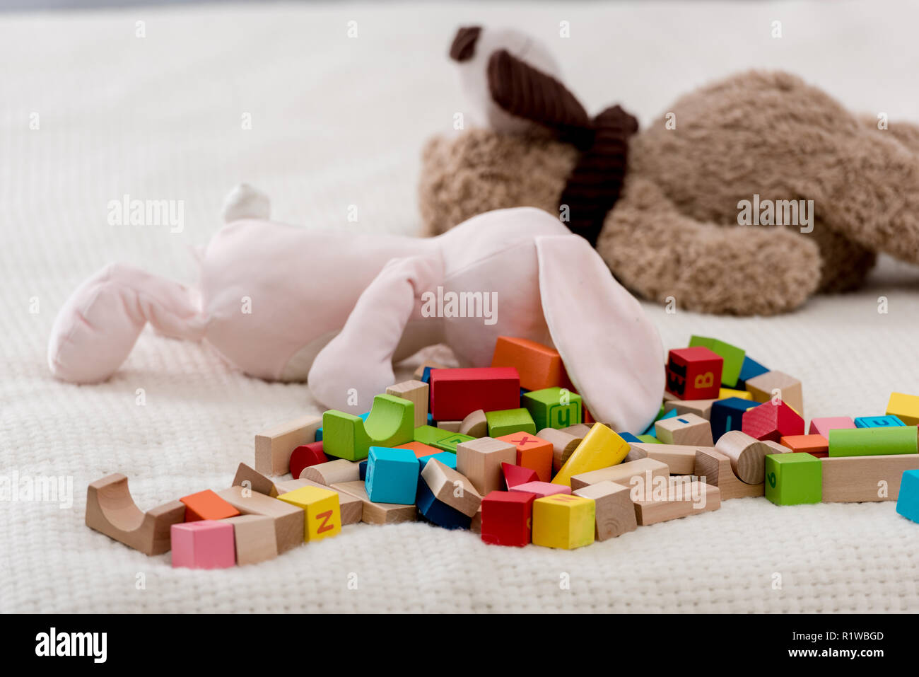 Colourful toy cubes and teddy bears lying on plaid Stock Photo - Alamy