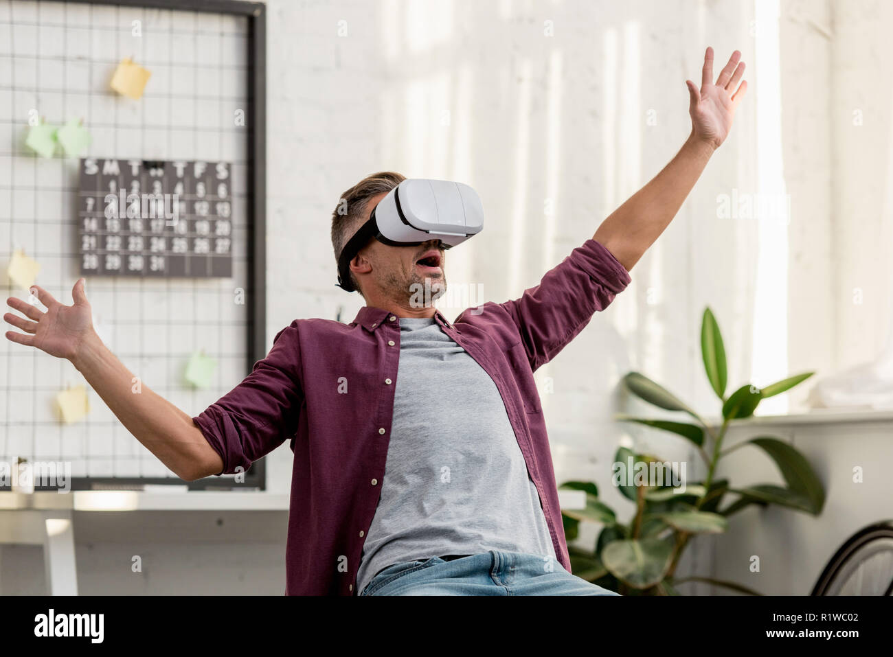 scared man sitting on chair in virtual reality headset Stock Photo - Alamy