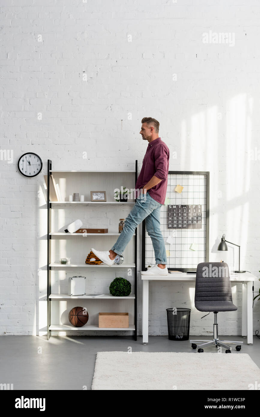 man stepping from desk at home office Stock Photo - Alamy