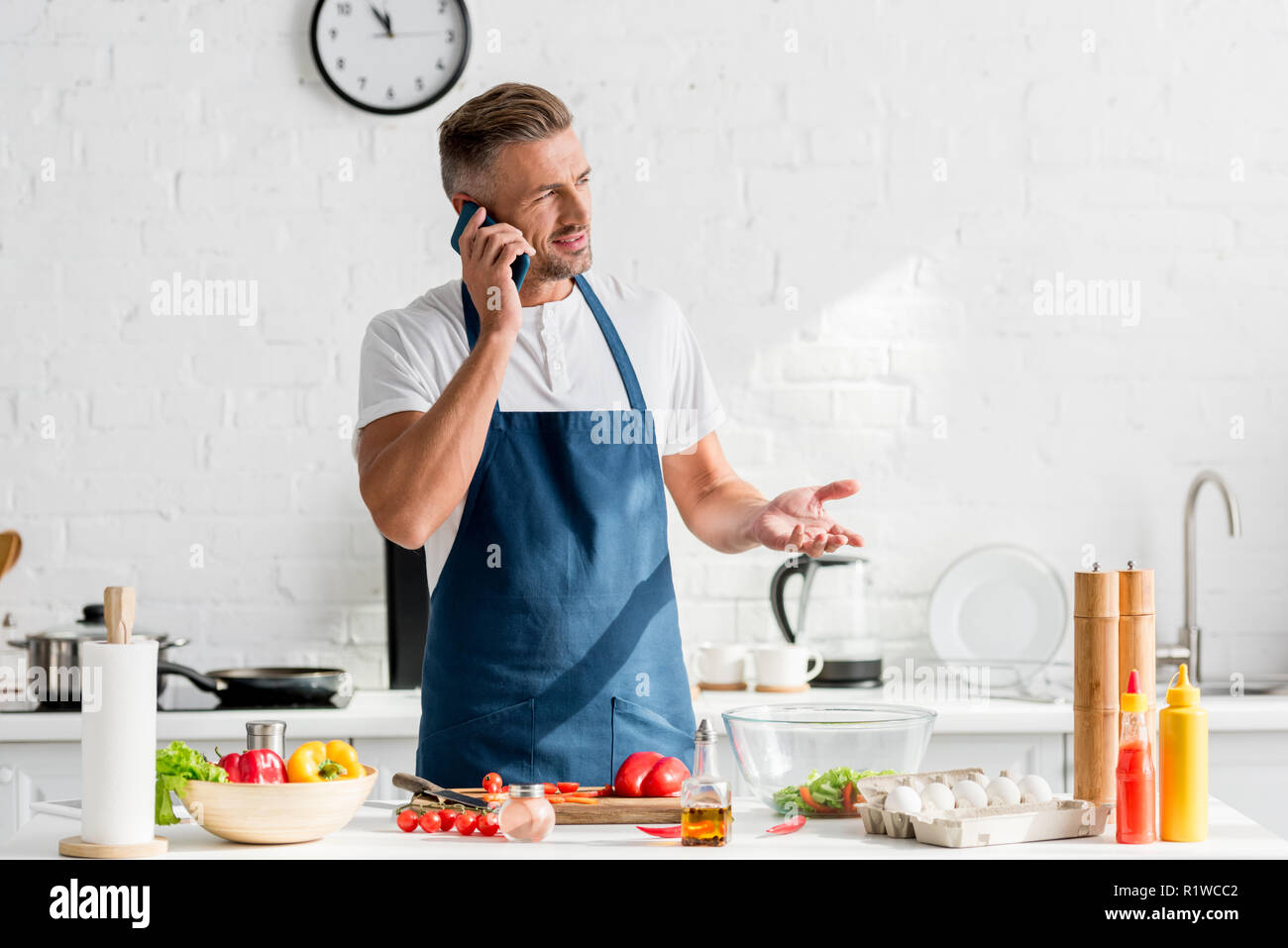 Man cooking food using smartphone hi-res stock photography and images ...