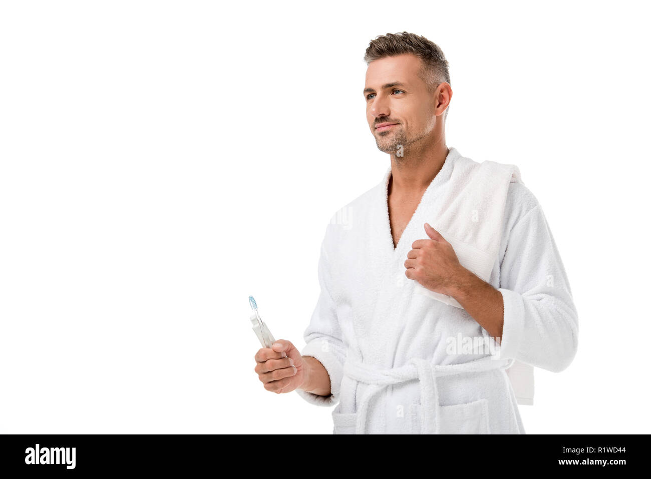 man in bathrobe with towel over shoulder holding toothpaste and ...