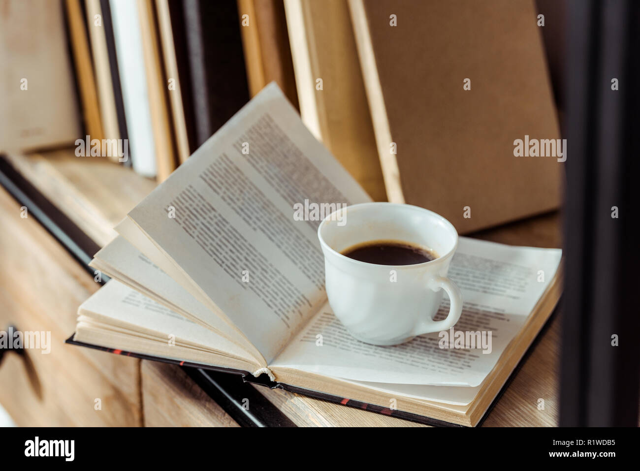 close up of open book with cup of coffee on bookshelf Stock Photo - Alamy
