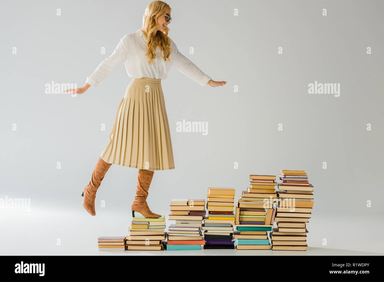 adult elegant woman balancing on vintage books Stock Photo - Alamy
