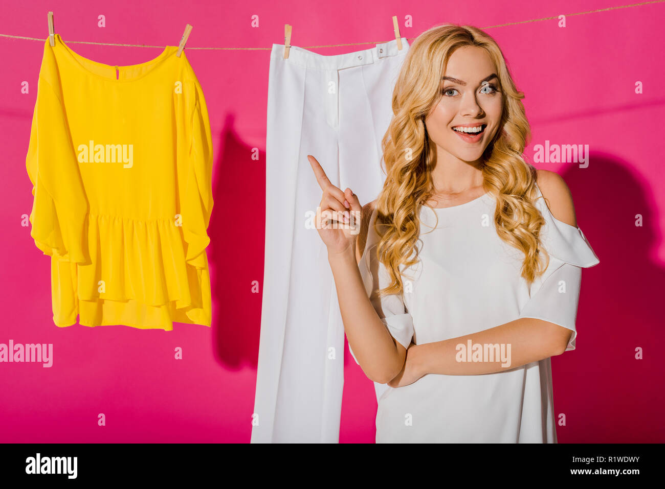 close up of beautiful woman pointing at clothes hanging on clothesline ...
