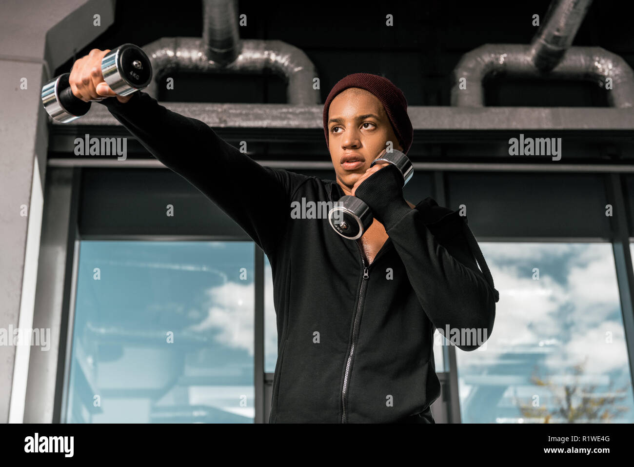 low angle view of young african american male boxer practicing with ...