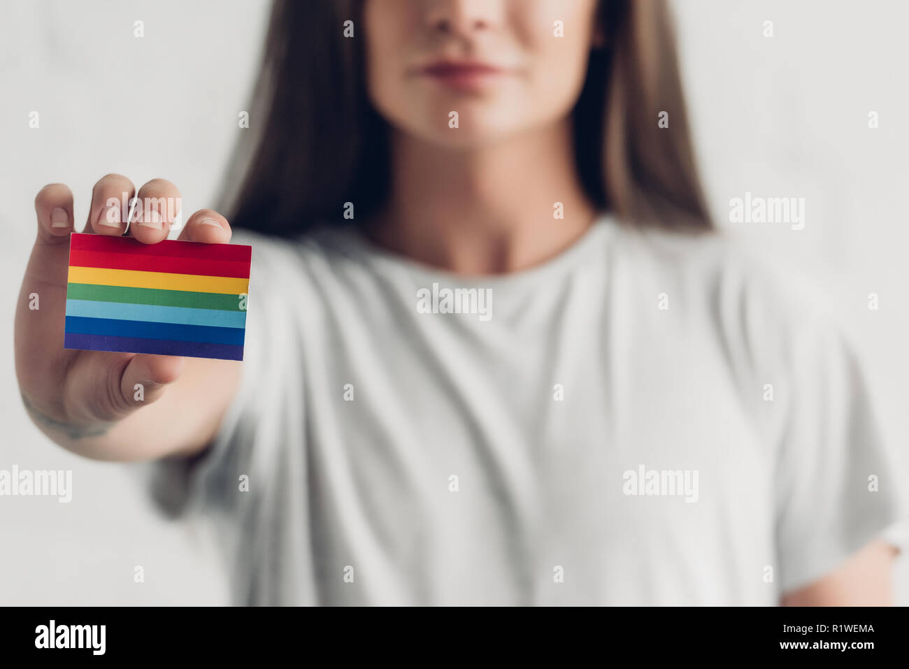close-up shot of young transgender man holding card with pride flag on ...