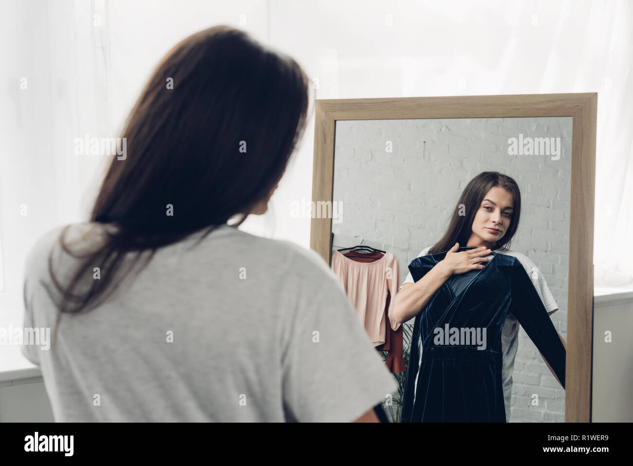 transgender man with dress looking at mirror at home Stock Photo - Alamy