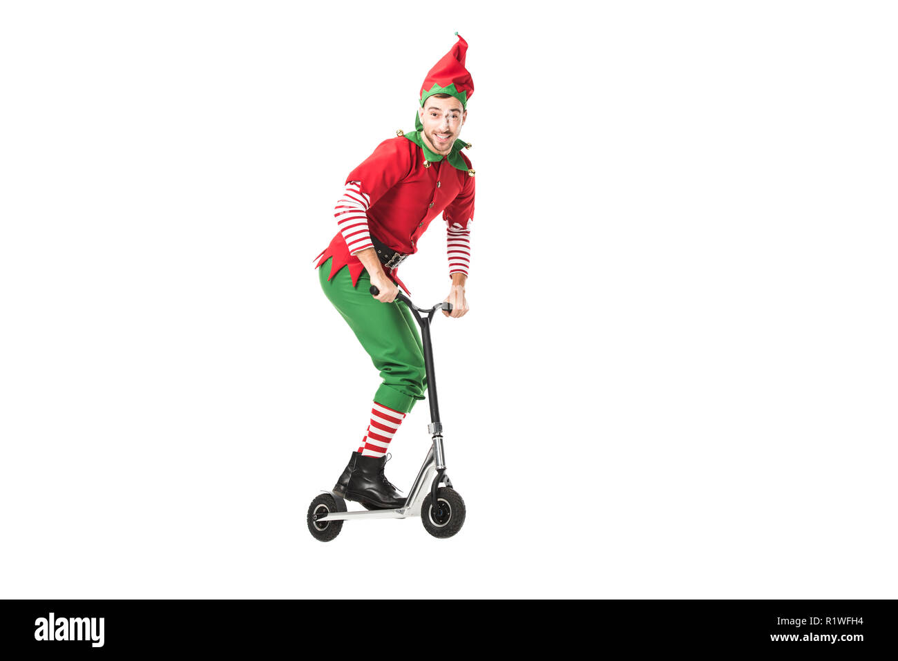 excited man in christmas elf costume jumping in air on push-cycle ...