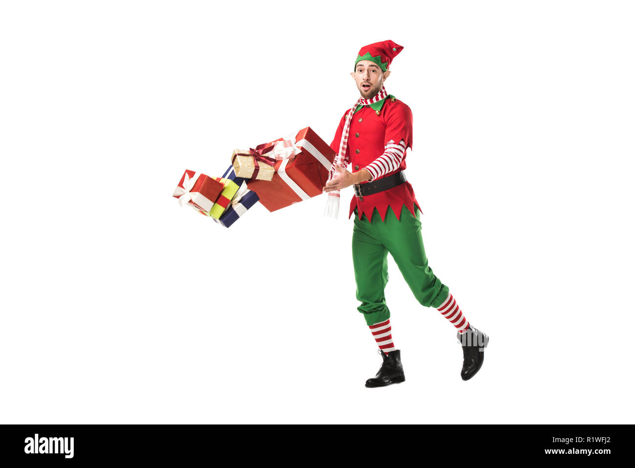 surprised man in christmas elf costume accidentally dropping pile of ...