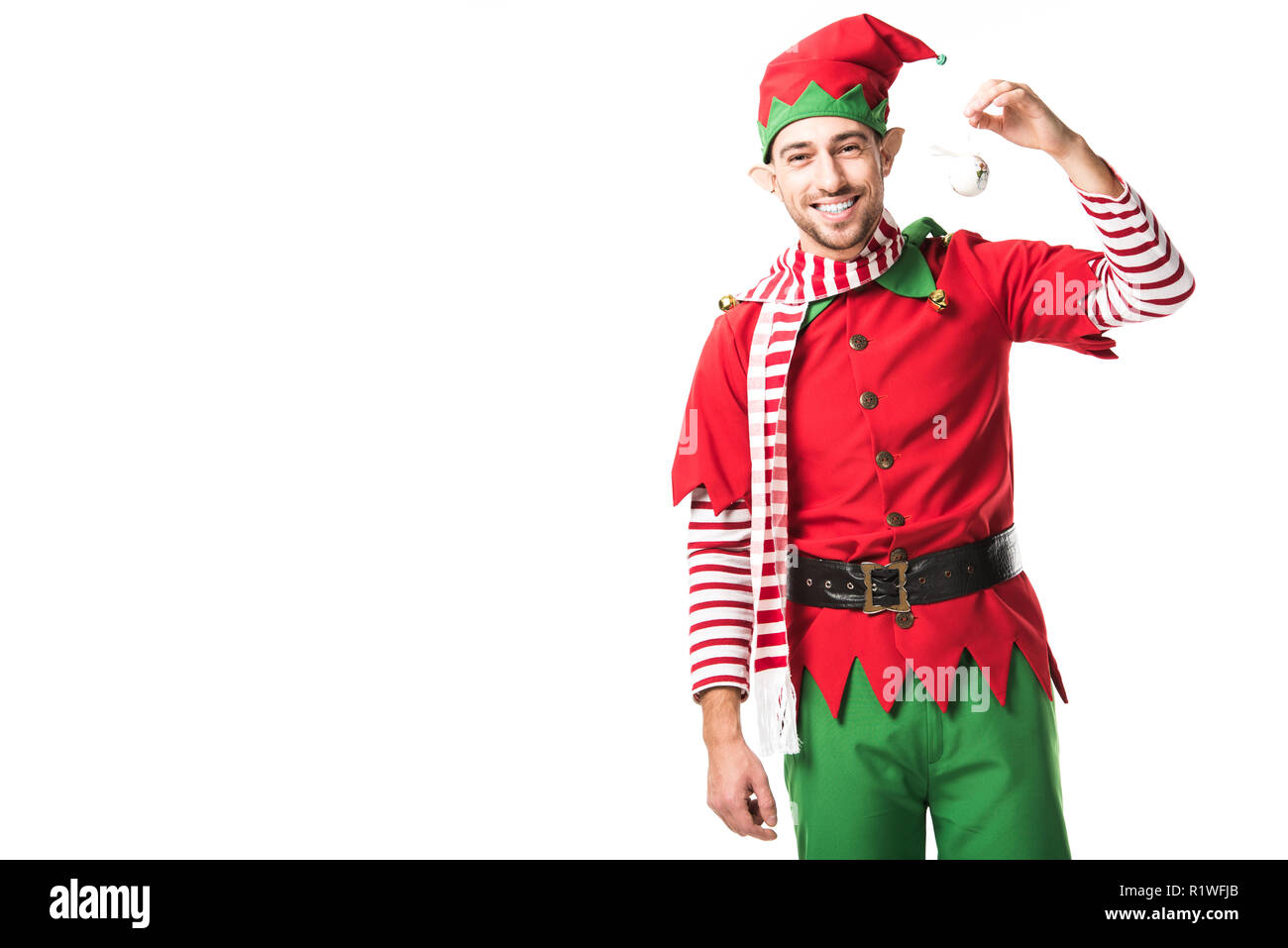 man in christmas elf costume holding bauble, smiling and looking at ...