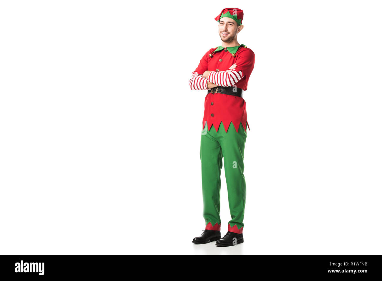man in christmas elf costume with crossed arms looking at camera ...