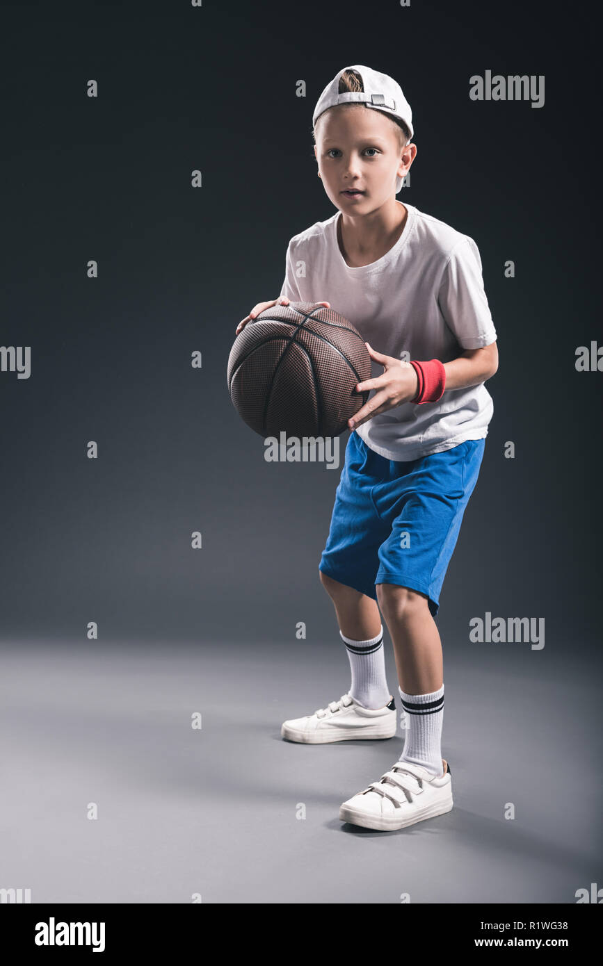 stylish boy playing basketball on grey background Stock Photo - Alamy