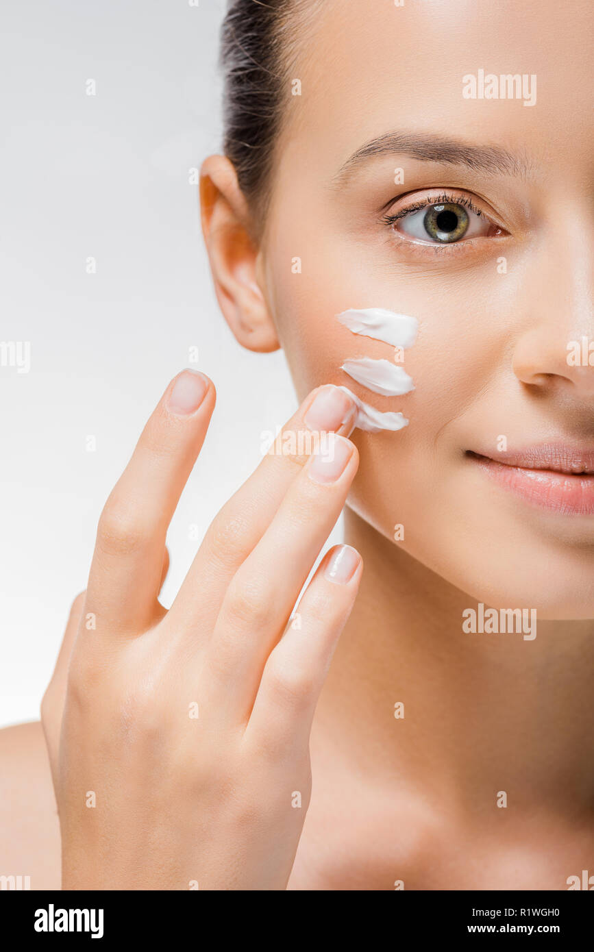 young beautiful woman applying white cream with fingers on cheek Stock ...