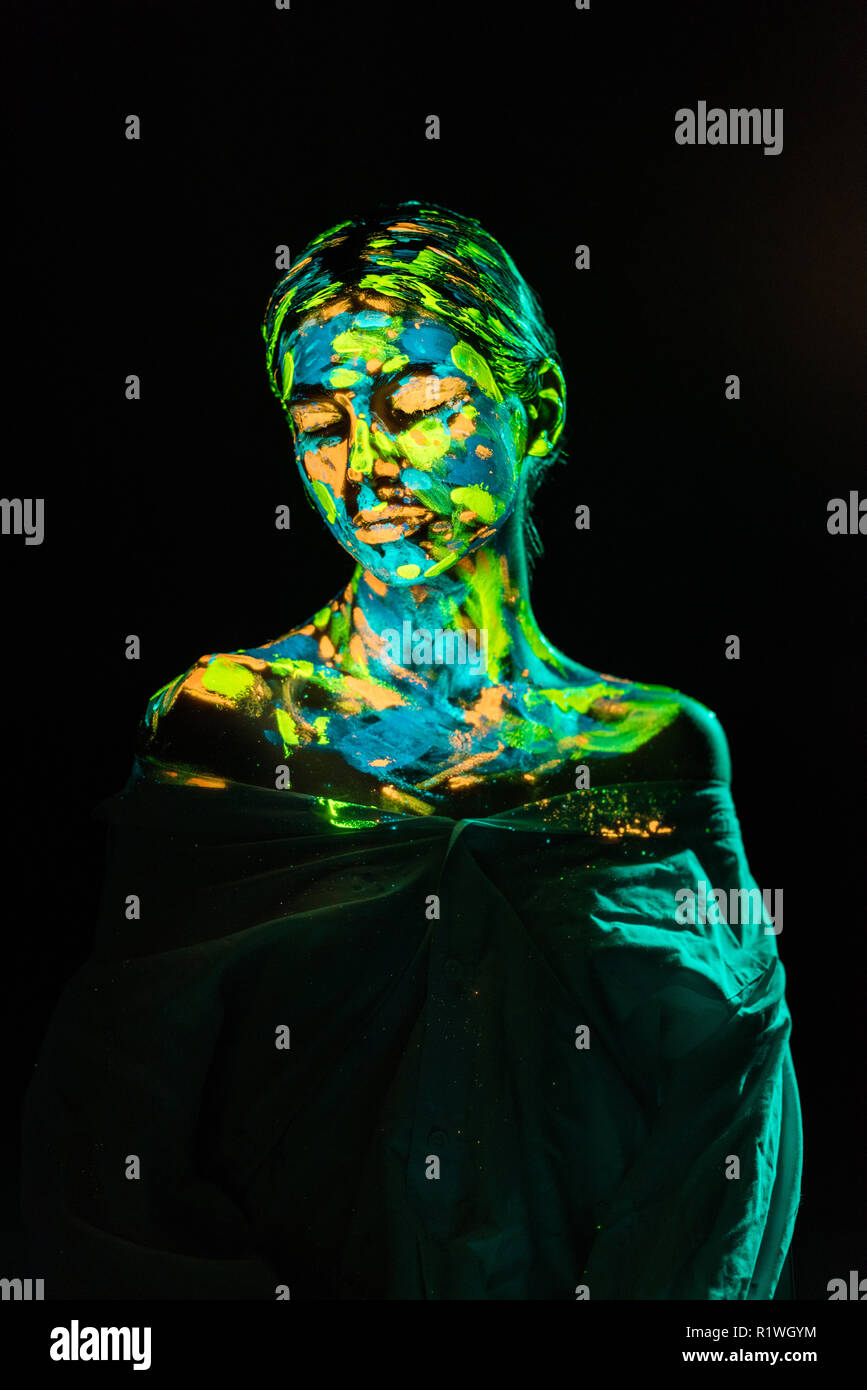 model with colorful neon paints on body posing on black backdrop Stock ...