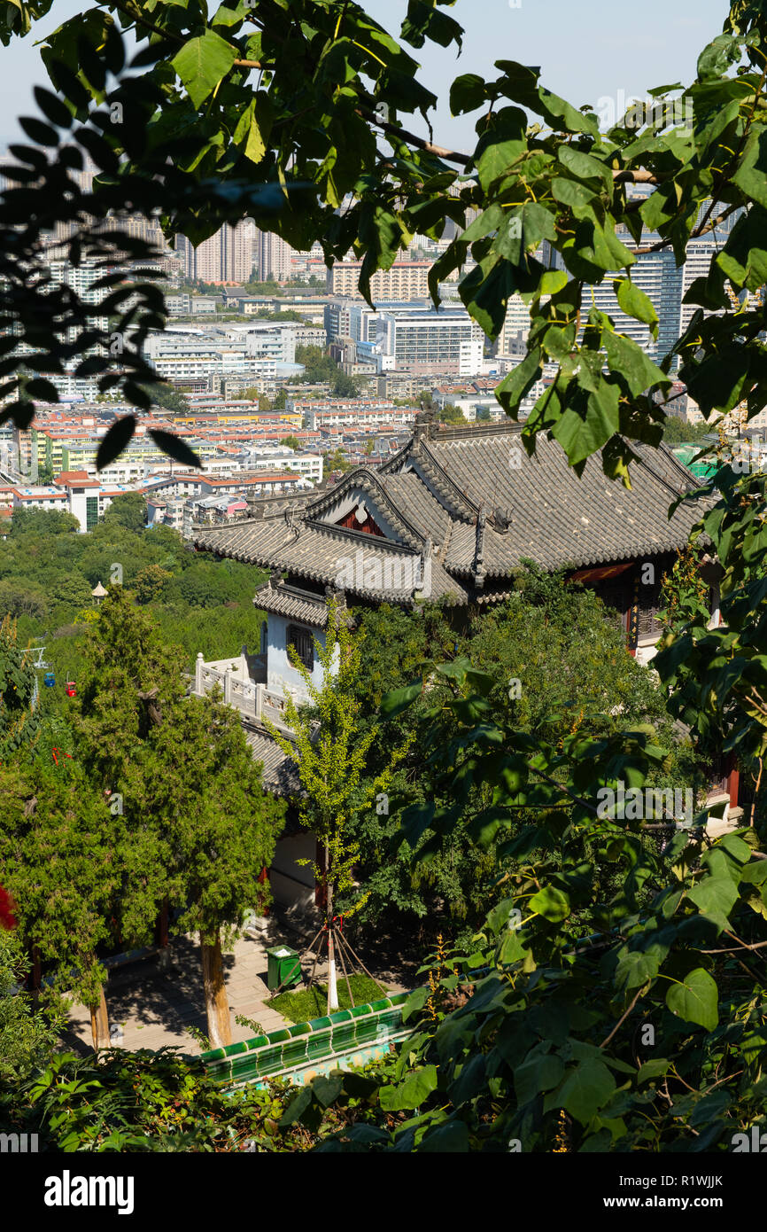 view of Jinan city over temple rooftop from 1000 Buddha Mountain, Jinan ...