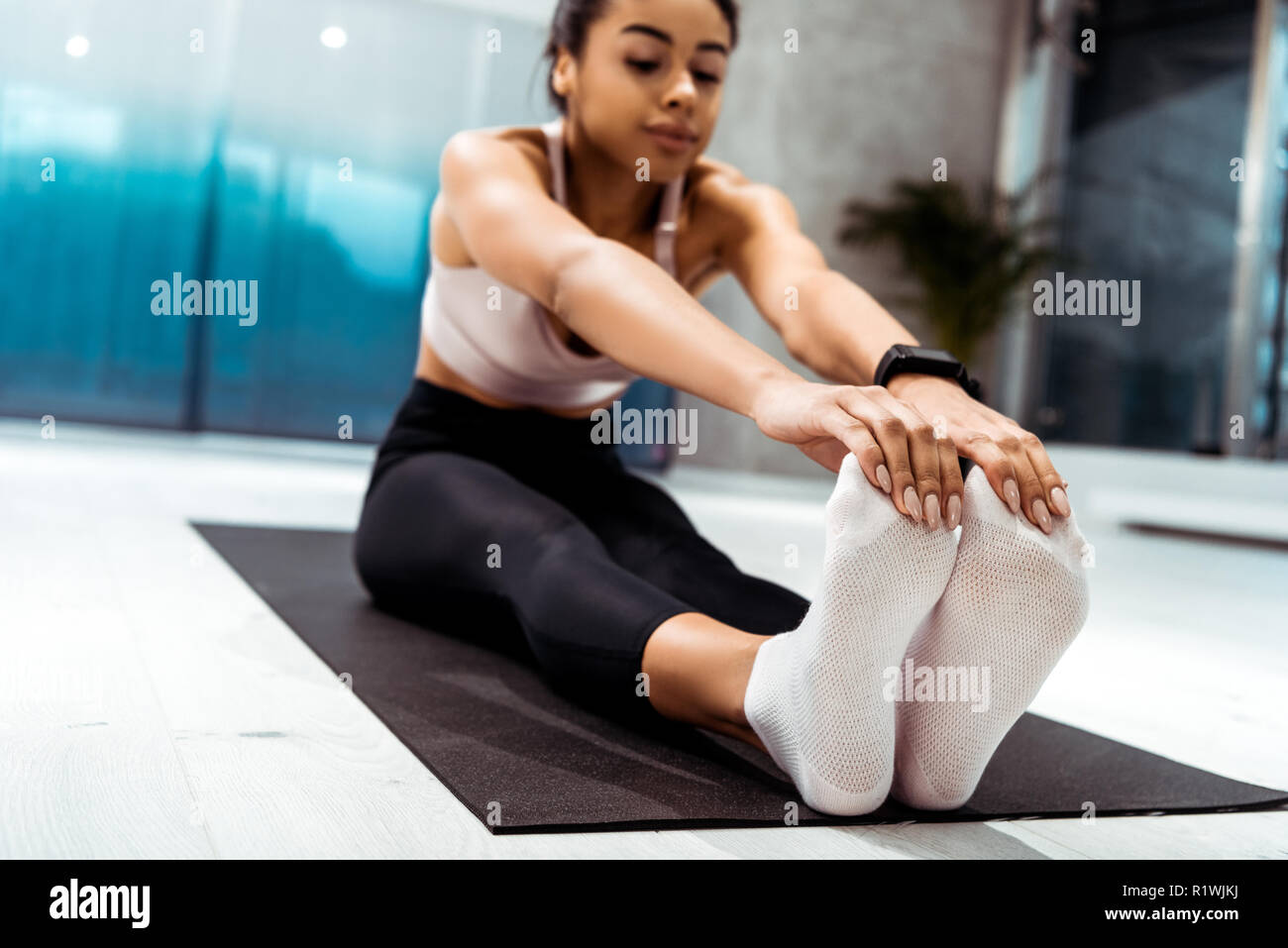 Young attractive sportive girl limbering up in sports centre Stock ...