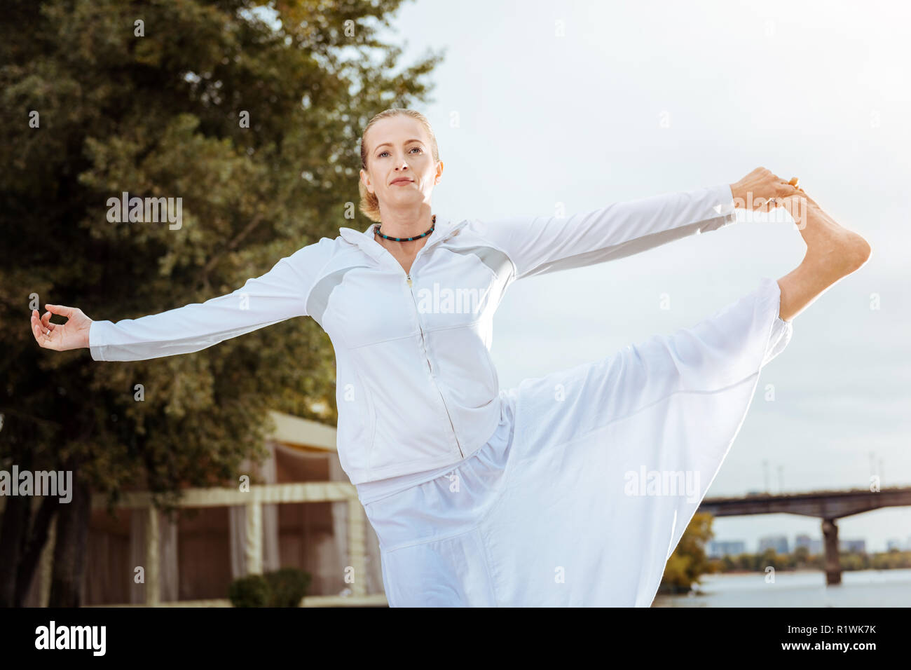 Young woman holding her big toe while standing on the one leg Stock ...