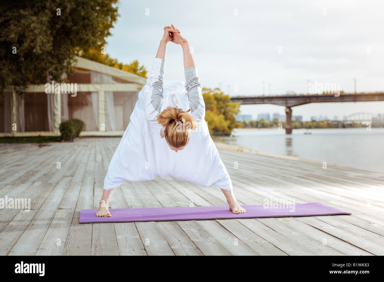 Young woman stretching her back muscles with yoga exercises Stock Photo ...