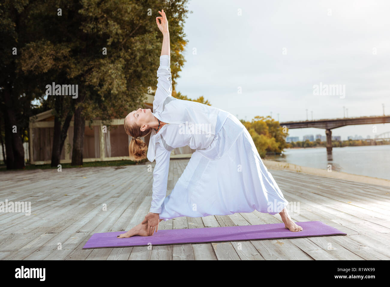 Relaxed woman standing in the triangle yoga pose Stock Photo - Alamy