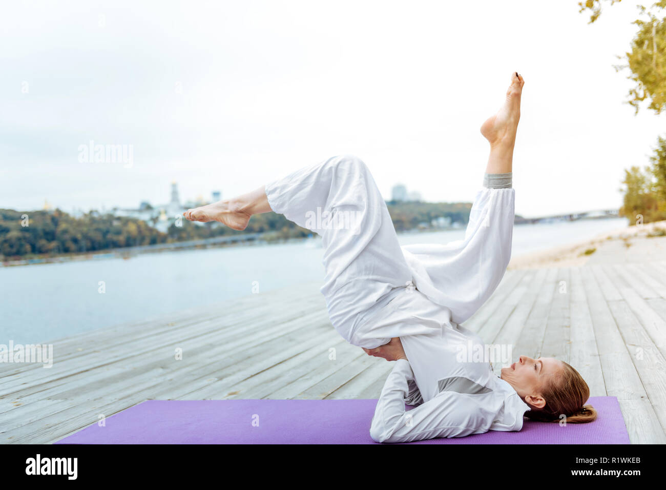 Woman doing morning exercises near the river Stock Photo - Alamy