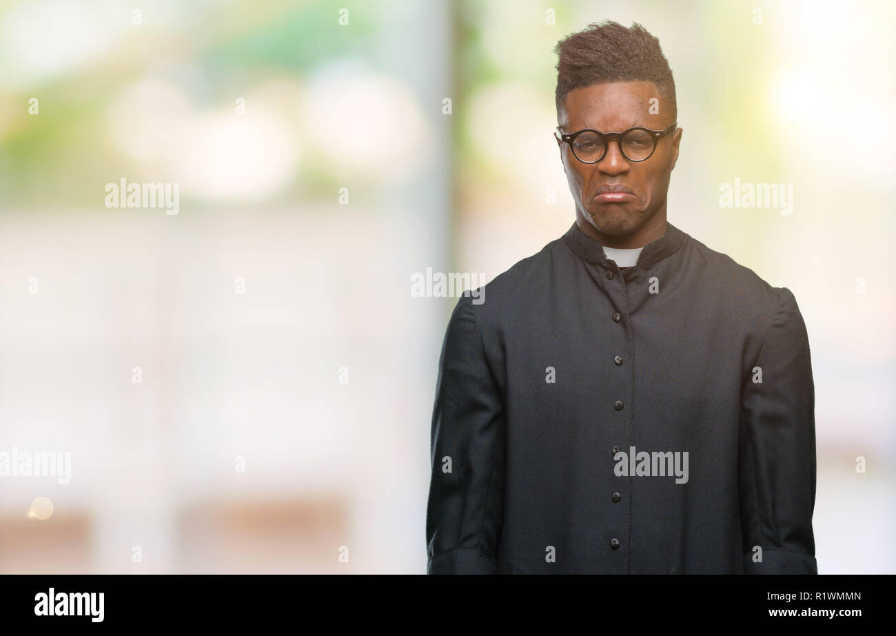 Young african american priest man over isolated background depressed ...