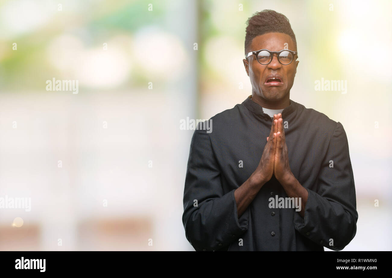 Young african american priest man over isolated background begging and ...