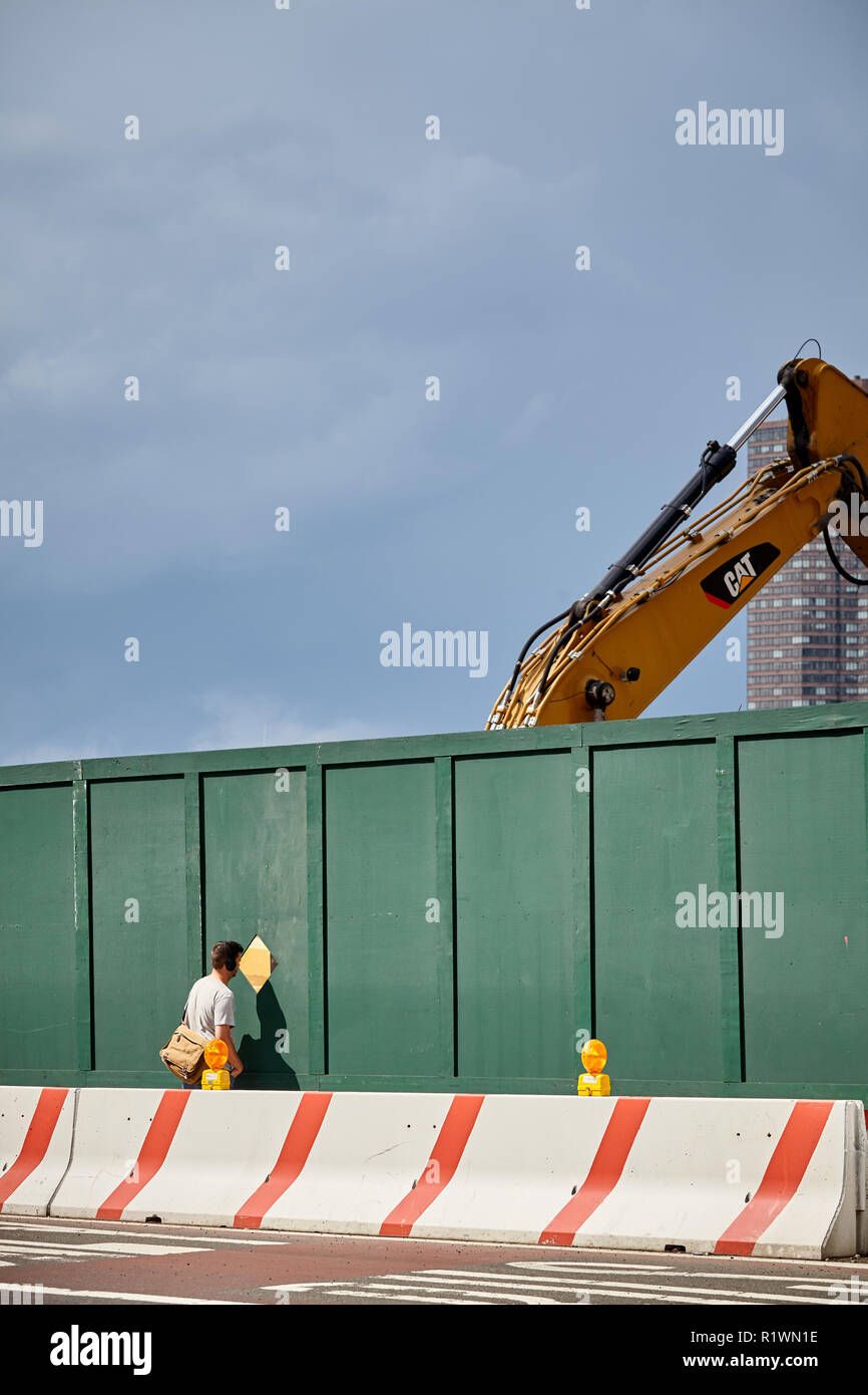 New York, USA - June 28, 2018: Man looks through a provisional fence ...