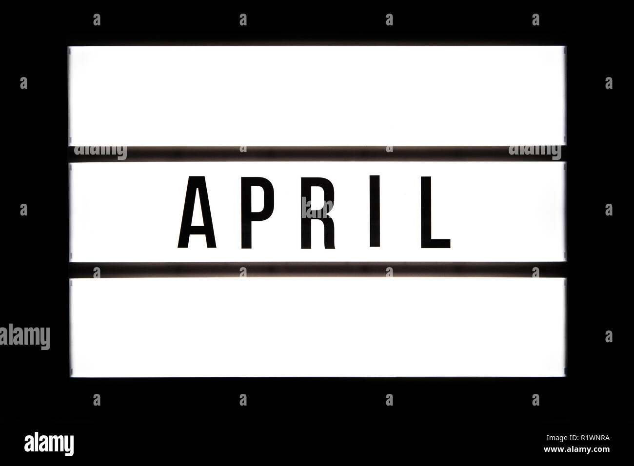 APRIL text in a light box, isolated over a black background Stock Photo ...