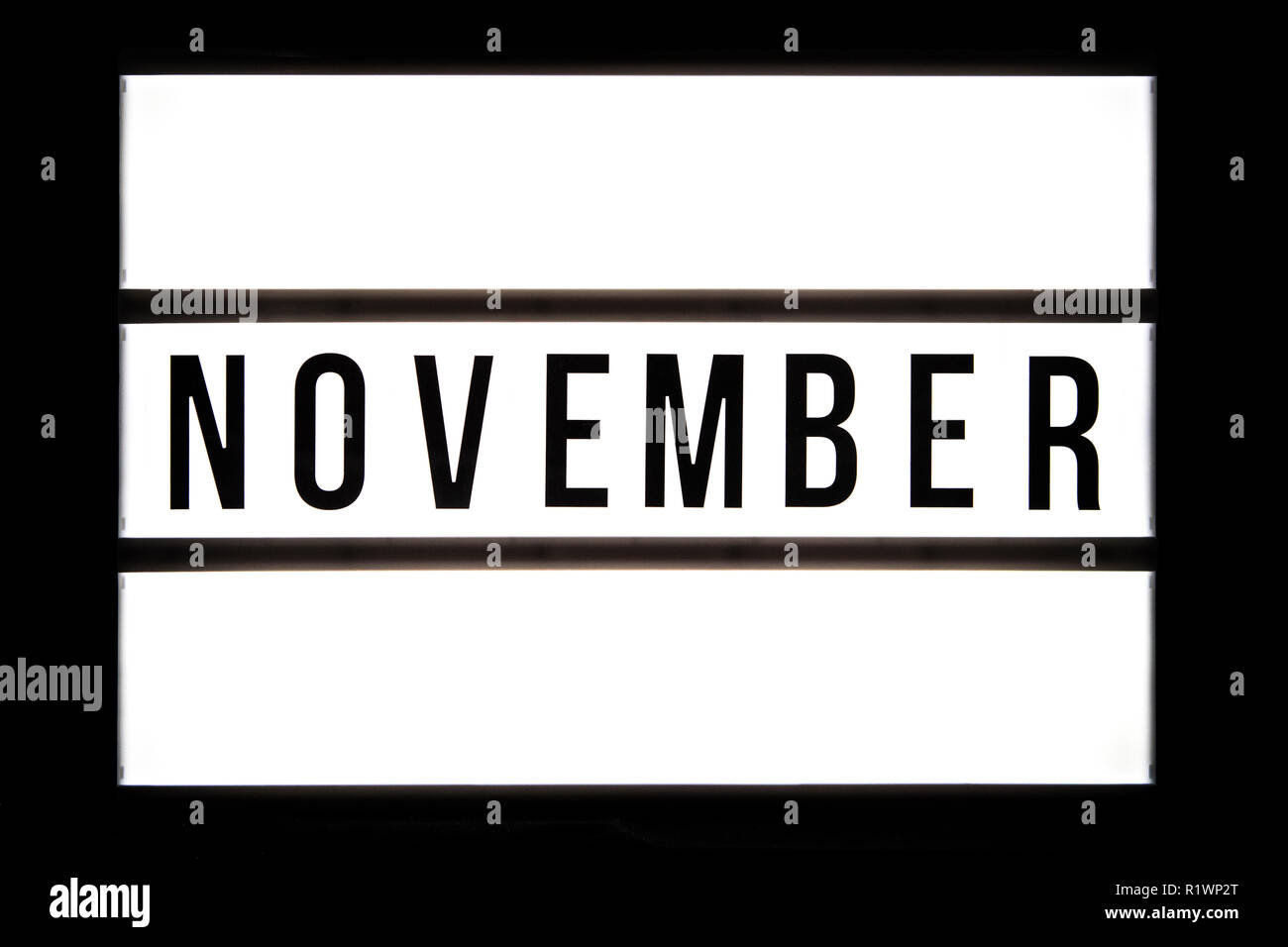 NOVEMBER text in a light box, isolated over a black background Stock ...
