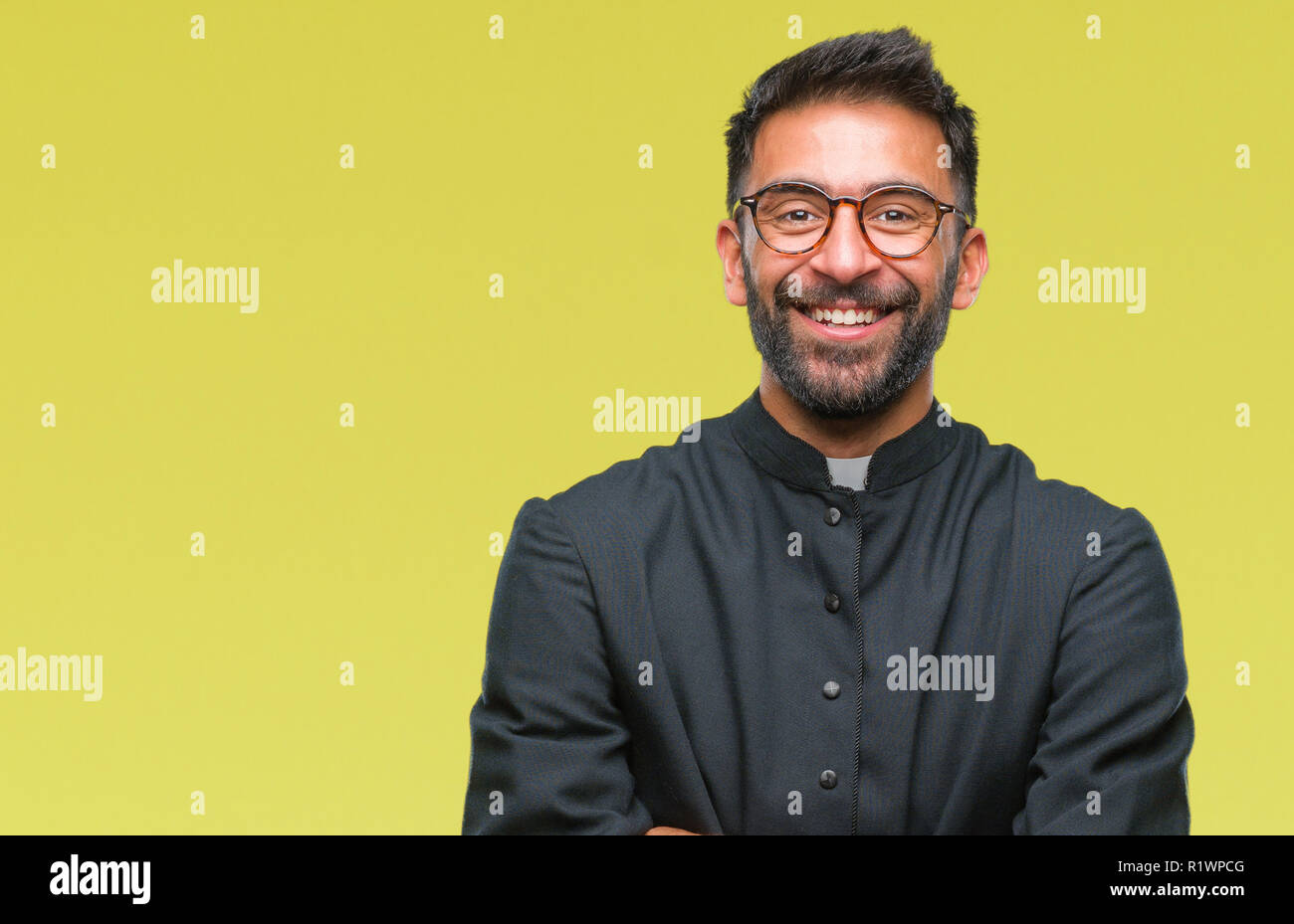 Adult hispanic catholic priest man over isolated background happy face ...