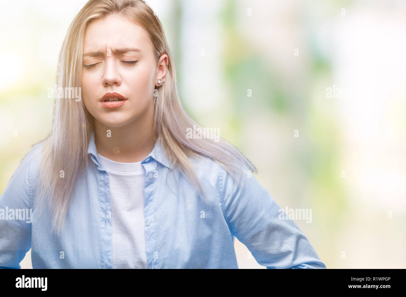 Young blonde woman over isolated background with hand on stomach ...
