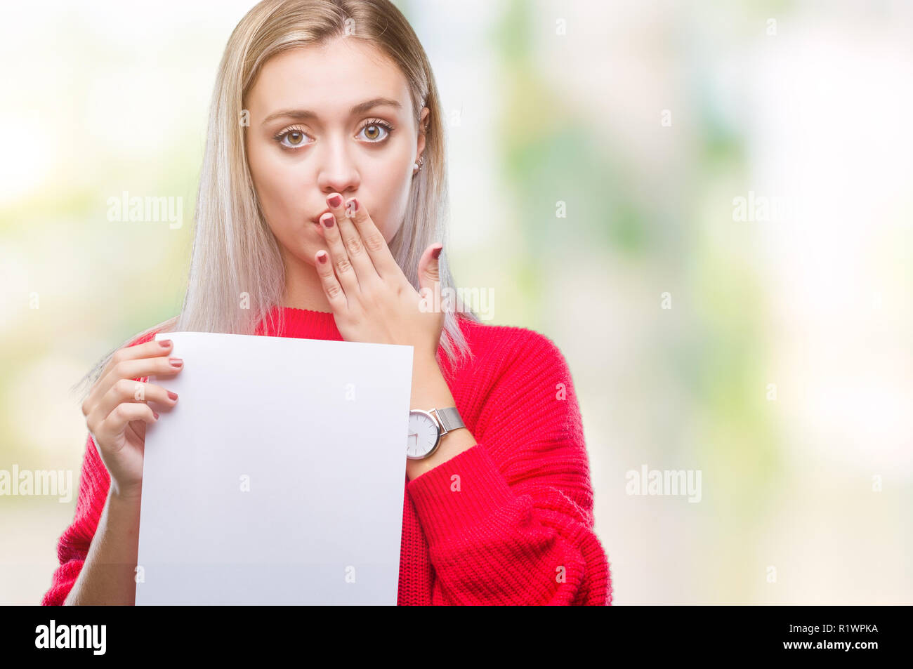 Young blonde woman holding blank paper sheet over isolated background ...
