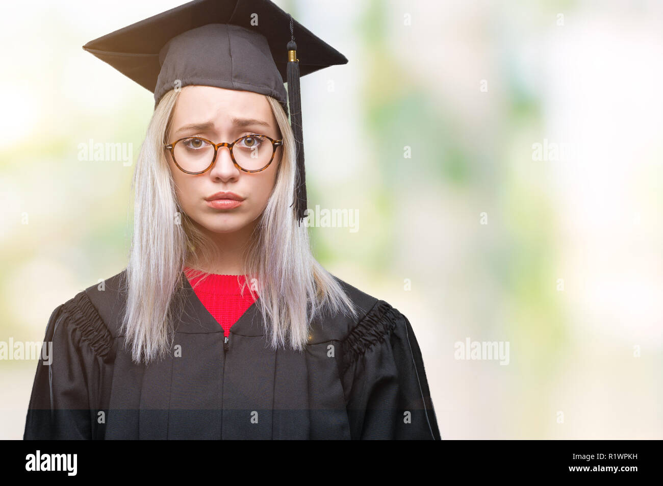 Young blonde woman wearing graduate uniform over isolated background ...