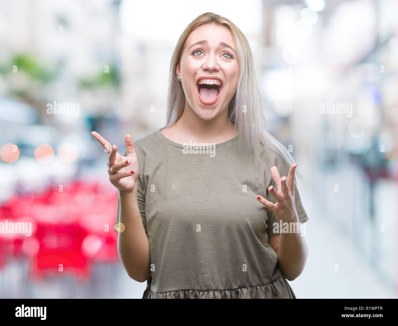 Young blonde woman over isolated background crazy and mad shouting and ...
