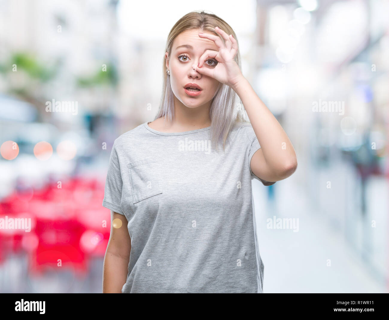 Young blonde woman over isolated background doing ok gesture shocked ...