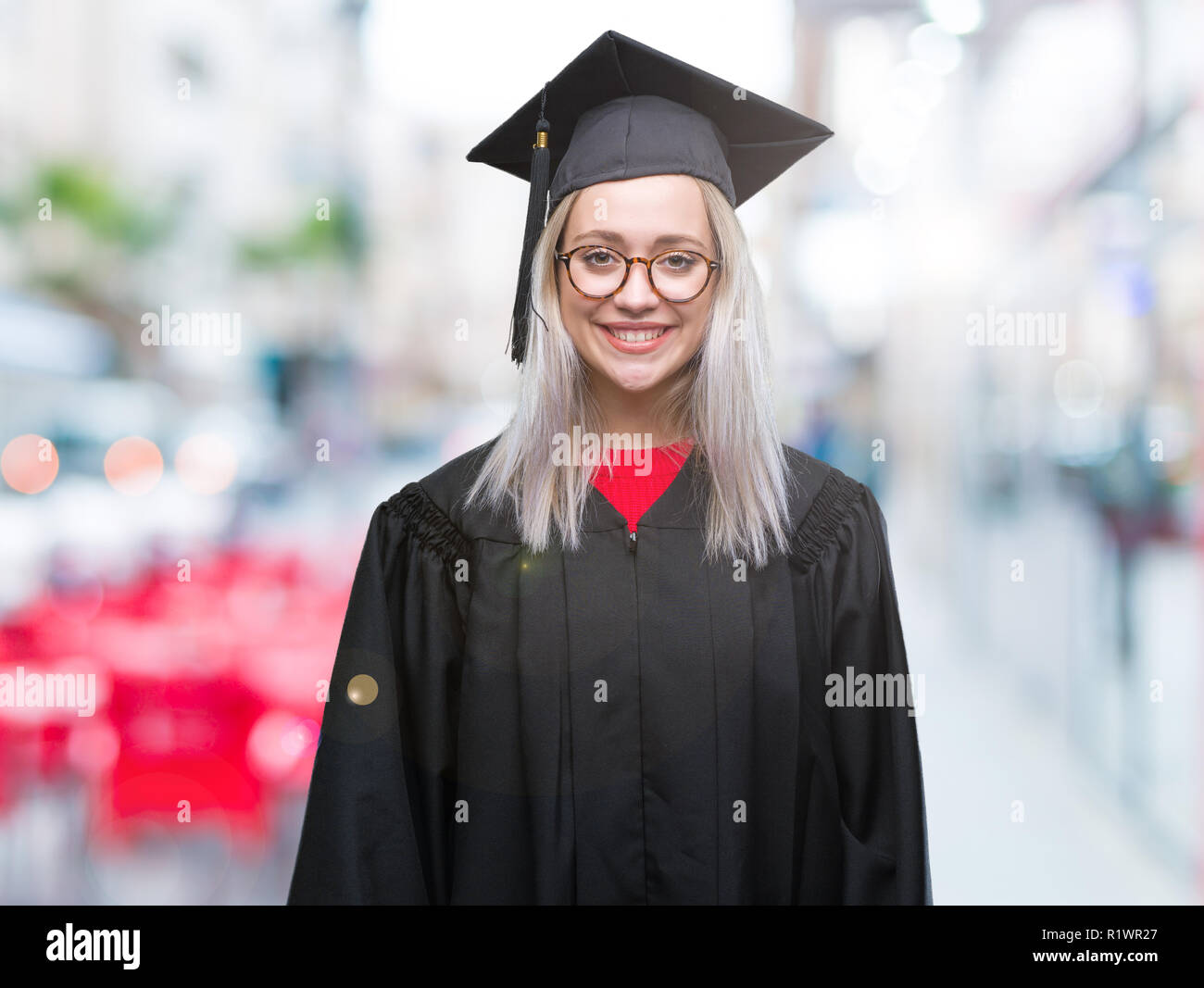 Young blonde woman wearing graduate uniform over isolated background ...