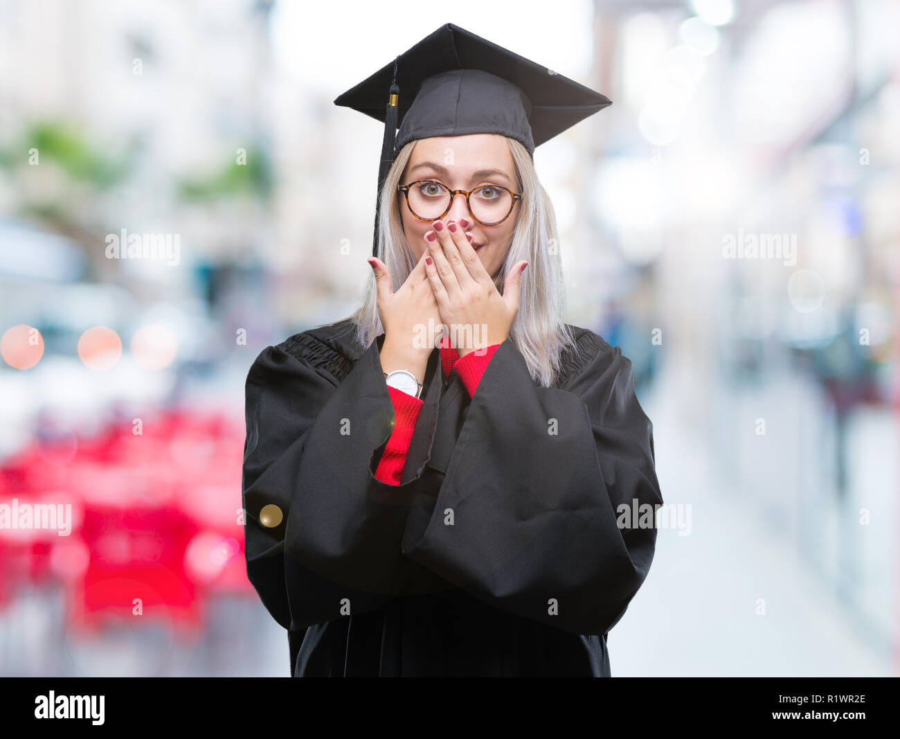 Young blonde woman wearing graduate uniform over isolated background ...