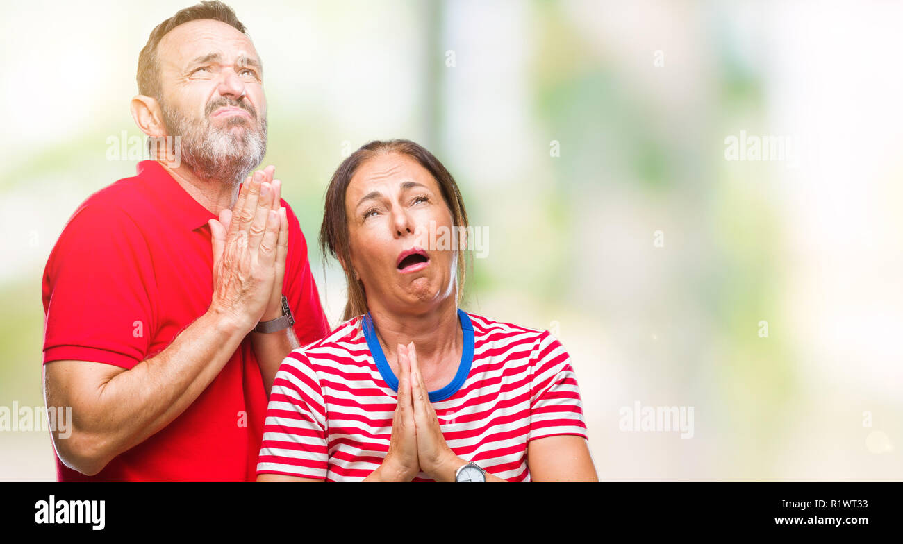 Middle age hispanic couple in love over isolated background begging and ...