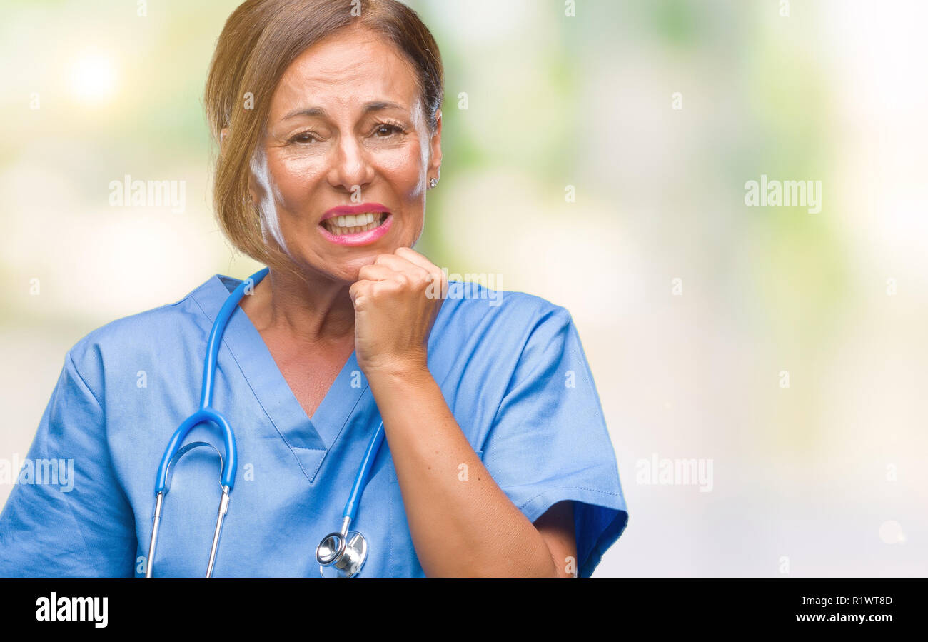 Middle age senior nurse doctor woman over isolated background looking ...