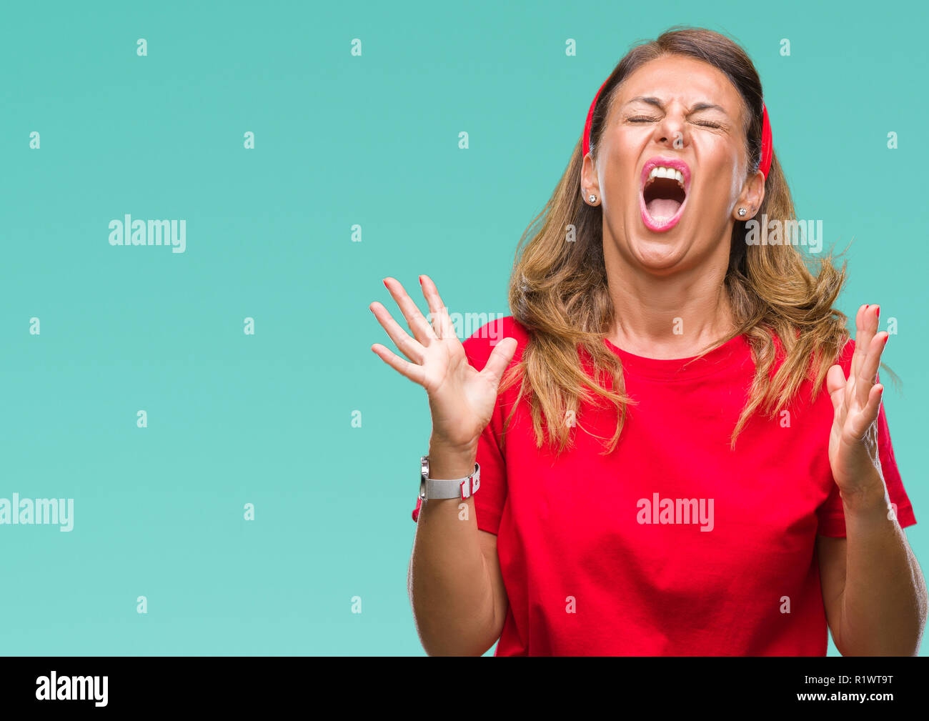 Middle age senior hispanic woman over isolated background crazy and mad ...