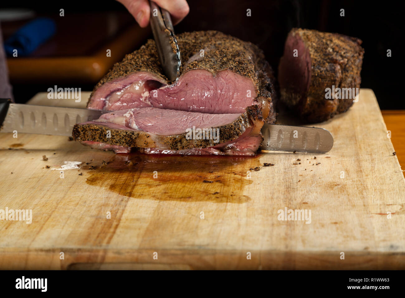 Close up of a large Prime rib roast being sliced for dinner service ...