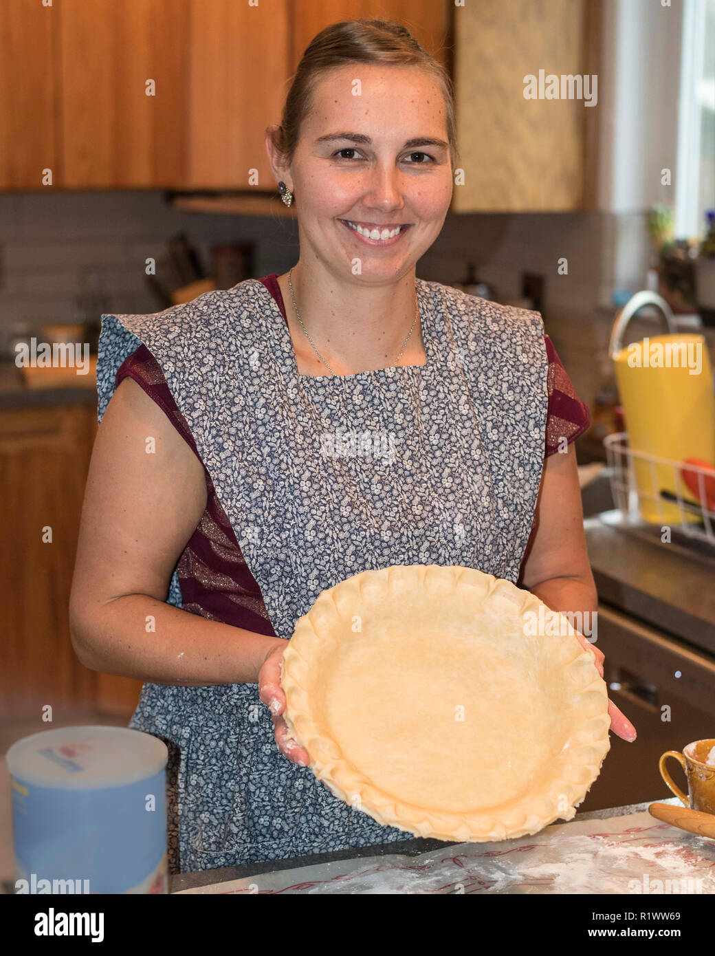 Uncooked pie crust in pie pan held up to camera by young women in real ...