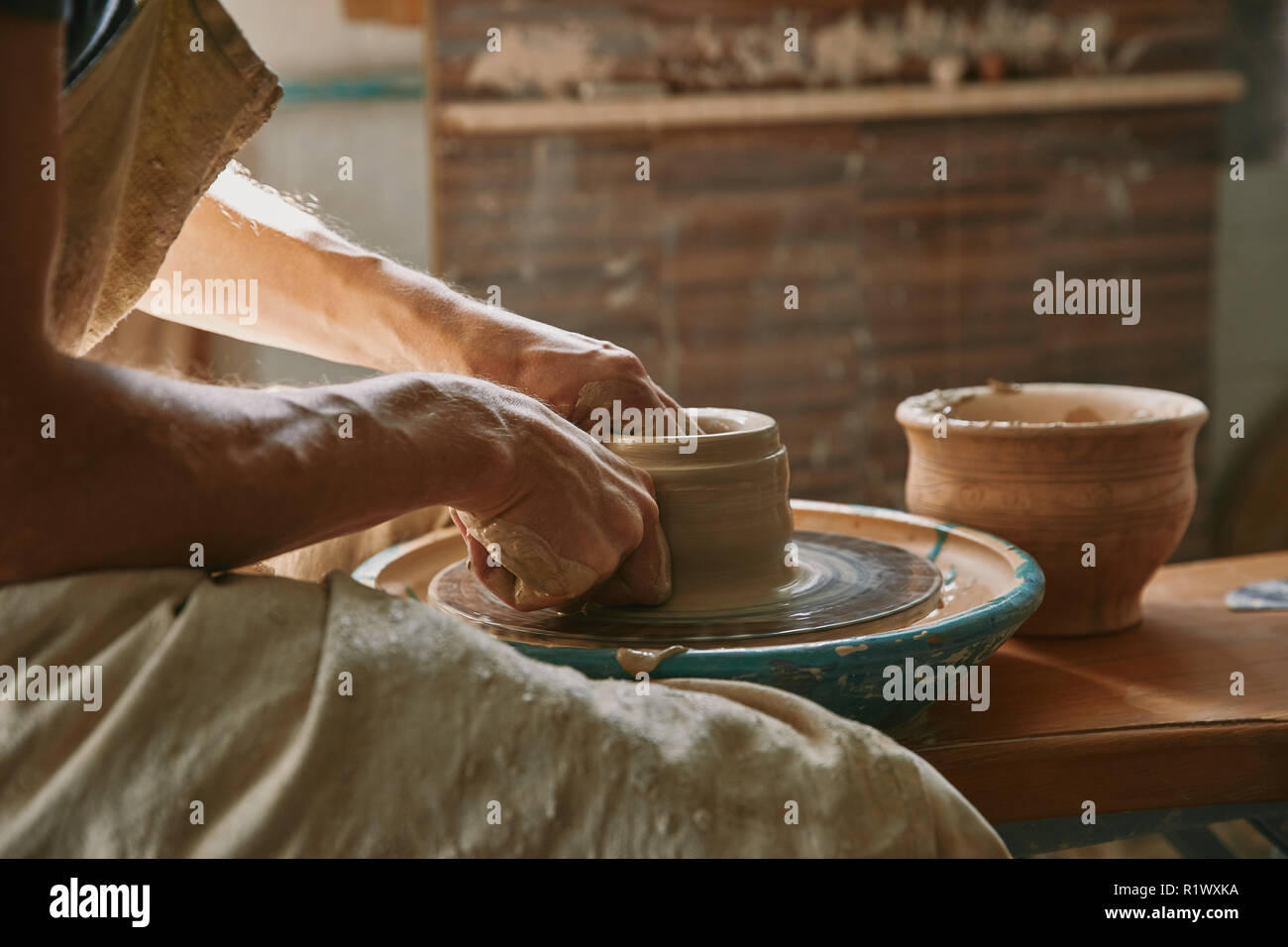 partial view of professional potter working on pottery wheel at ...