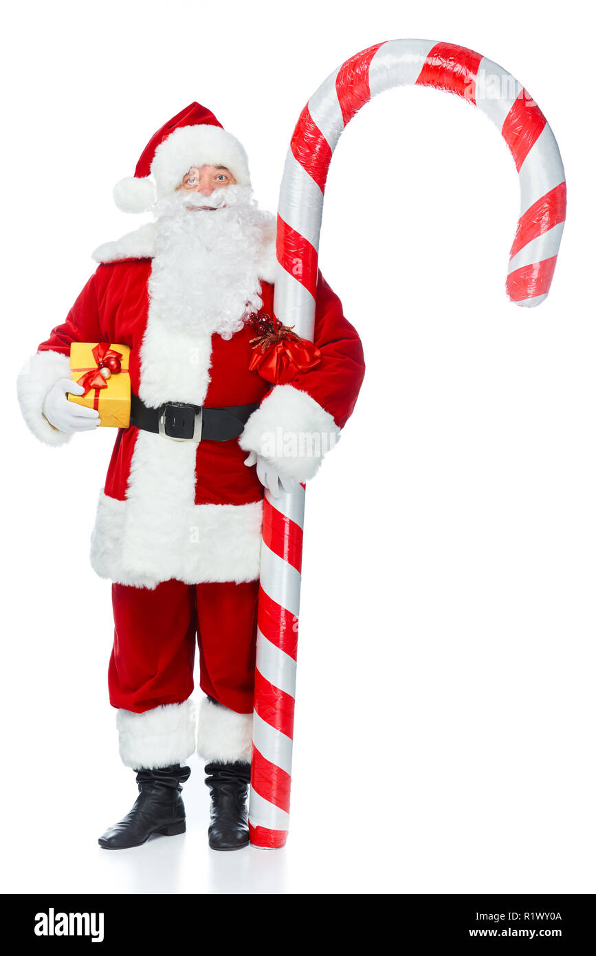 santa claus standing with big candy cane and christmas gift isolated on ...