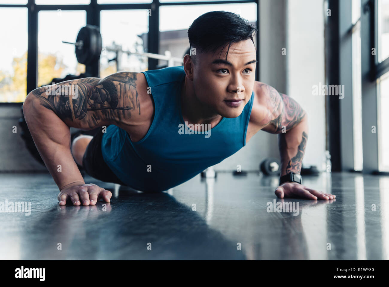 concentrated young asian sportsman doing plank exercise at gym Stock ...