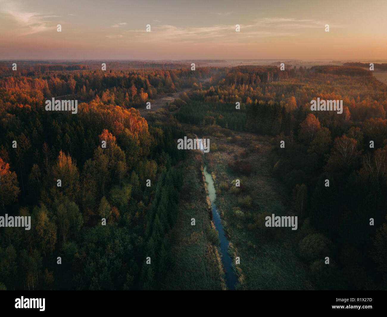 Foggy sunrise over river surrounded by agriculture fields and woods ...