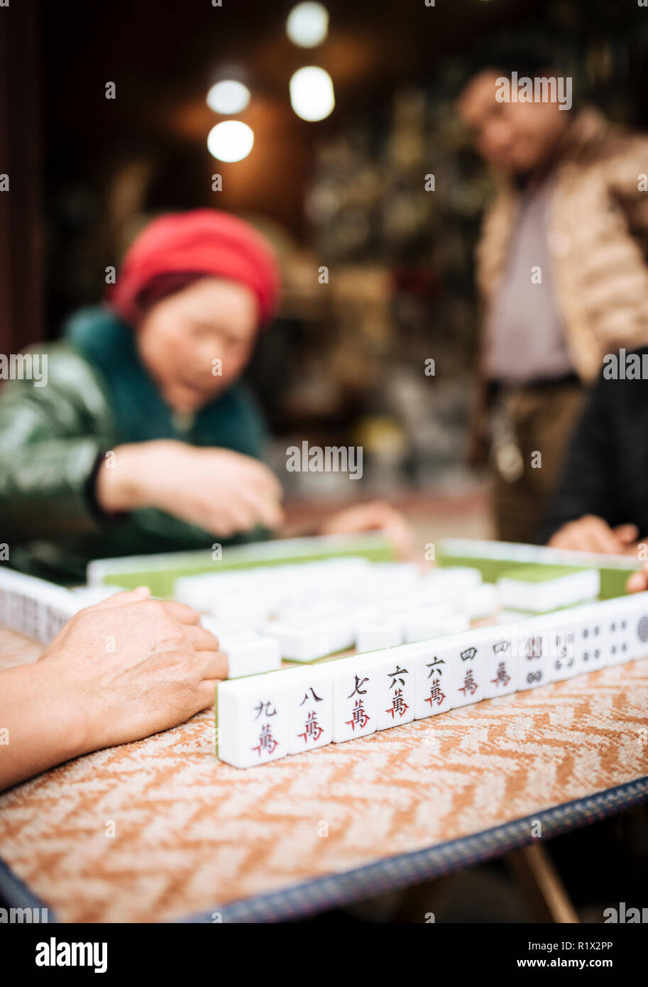 Women playing traditional Chinese game of Mahjong on street, Dali ...
