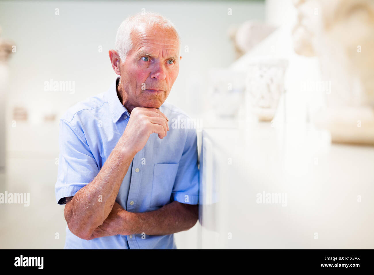 Attentive mature man observing sculptures exhibition in art museum ...